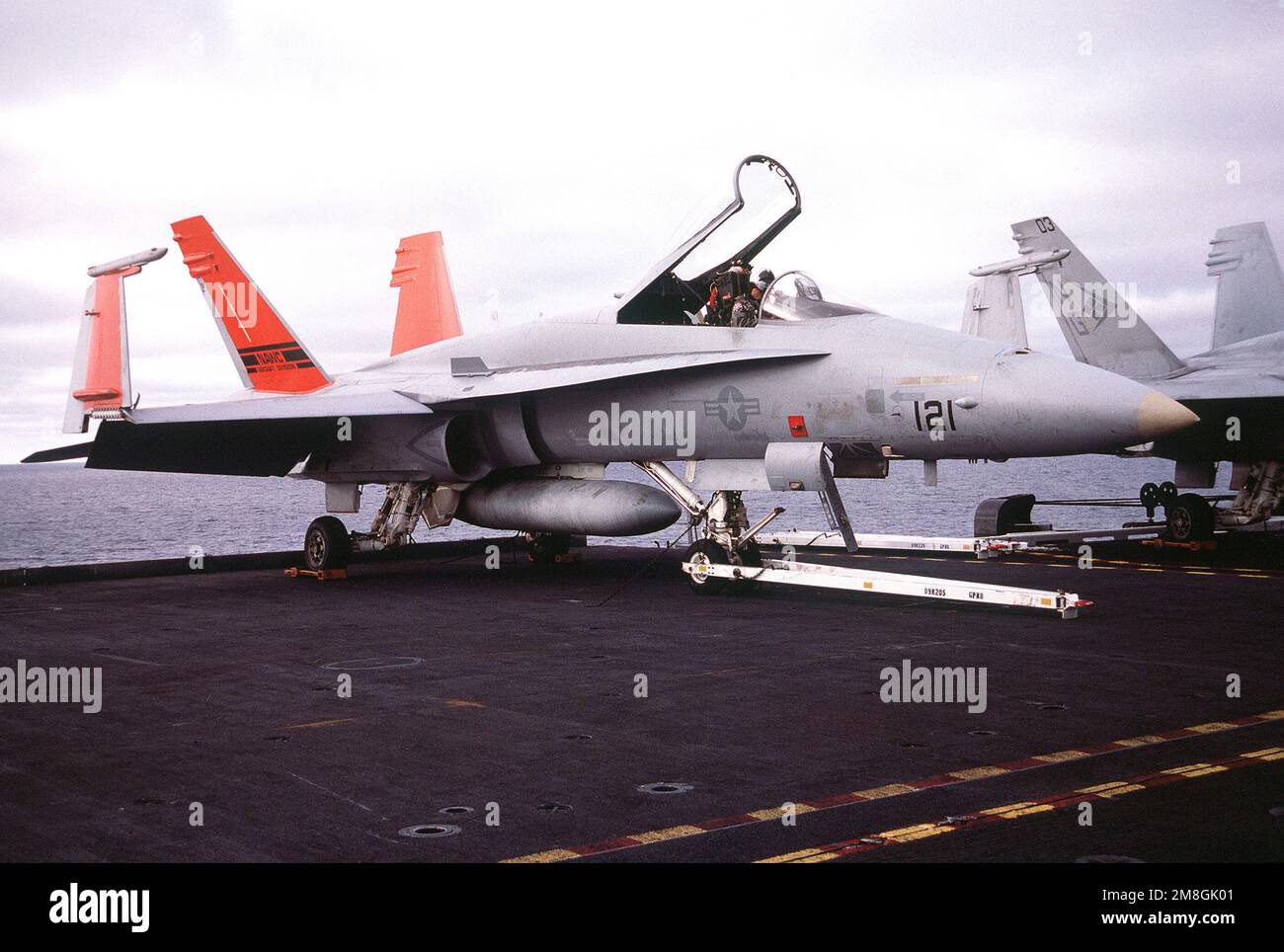 An F/A-18A Hornet aircraft stands chocked to the flight deck as the ...