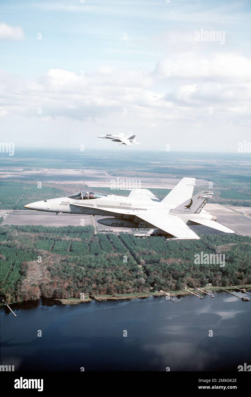 An air-to-air left side view of two Strike Fighter Squadron 136 (VFA ...