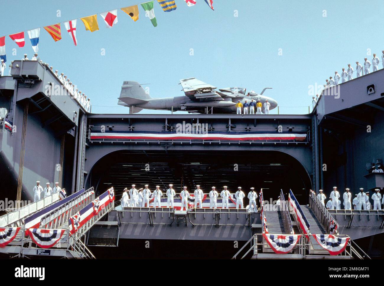 Crew members man the rails aboard the nuclear-powered aircraft carrier ...