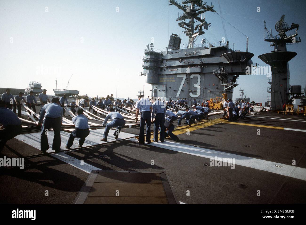 Crew members prepare to set up an arresting barricade on the flight ...