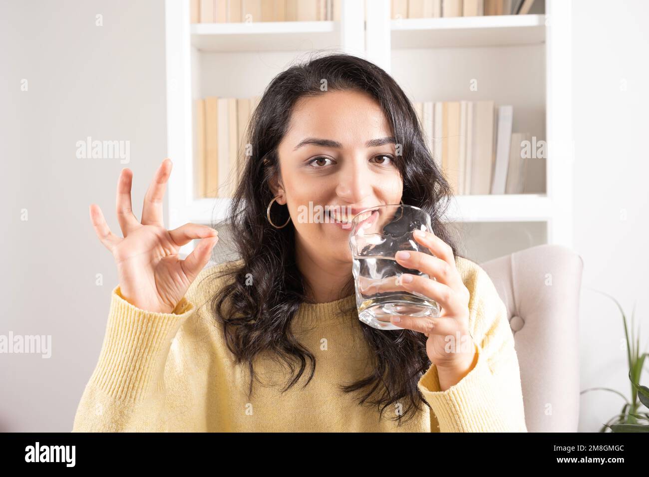 Woman recommending drink water. Head shot portrait of smiling young ...