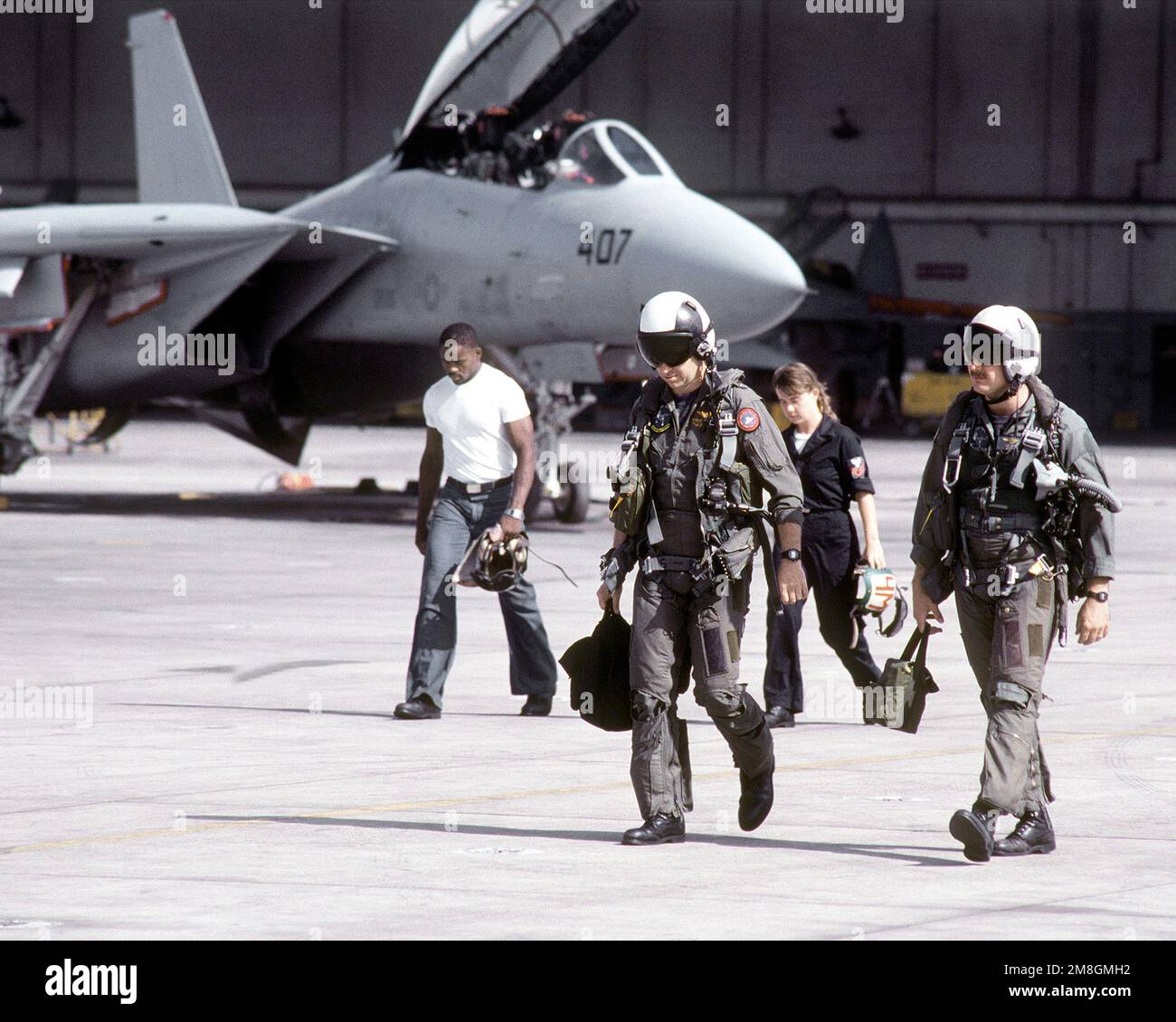A pilot and radar intercept officer, both of Fighter Squadron 124 (VF-124), walk off the flight ...