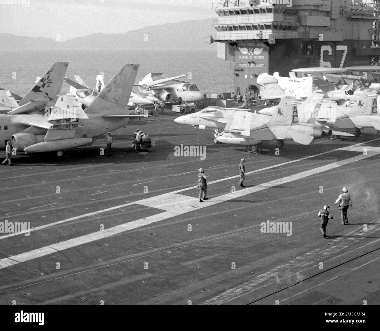 Crewmen position aircraft on the flight deck of the aircraft carrier ...