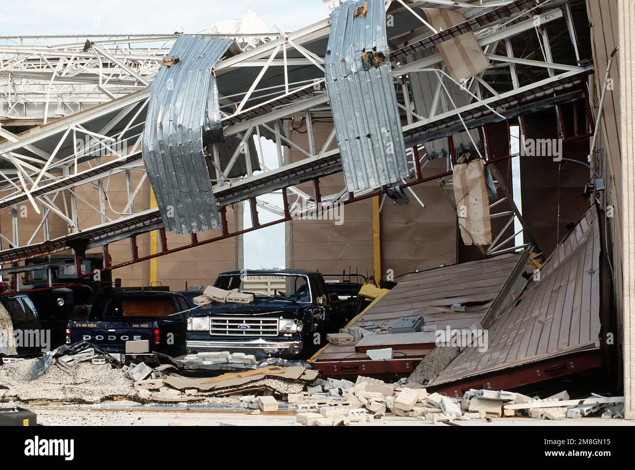 Trucks stand in a demolished hangar which sustained the damage during ...
