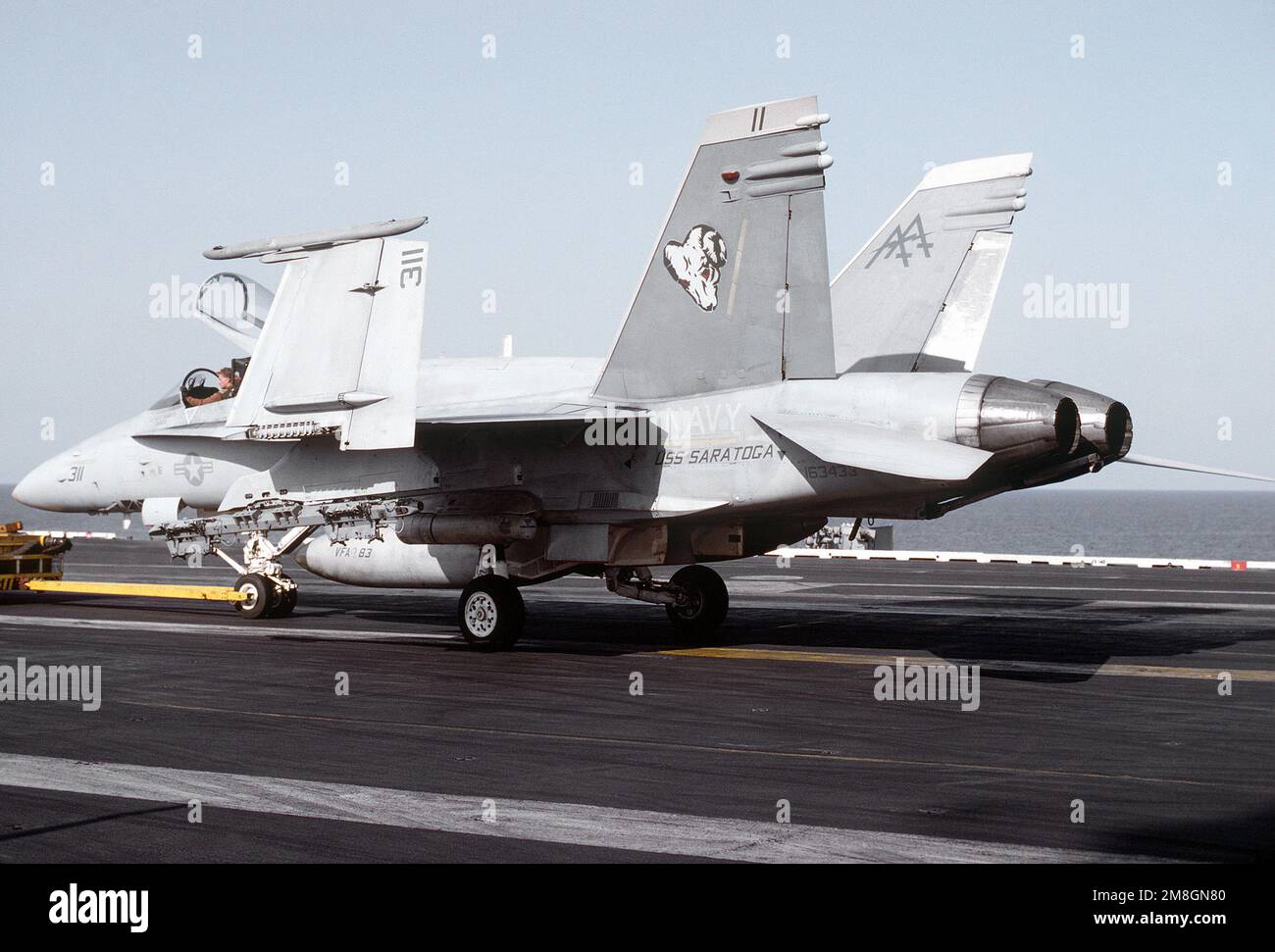 A plane captain sits in the cockpit of a Strike Fighter Squadron 83 ...