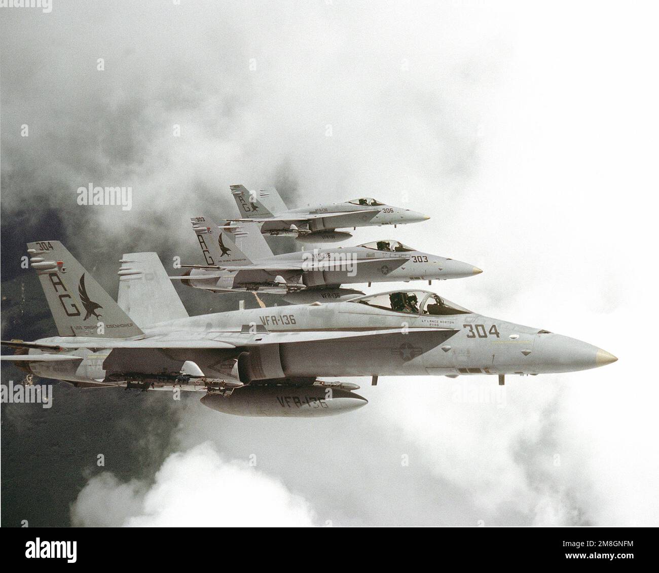 An air-to-air, right side view of three Strike Fighter Squadron 136 ...