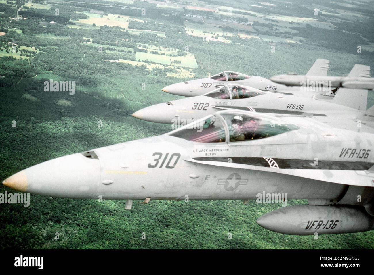 An air-to-air, left side view of three Strike Fighter Squadron 136 (VFA ...