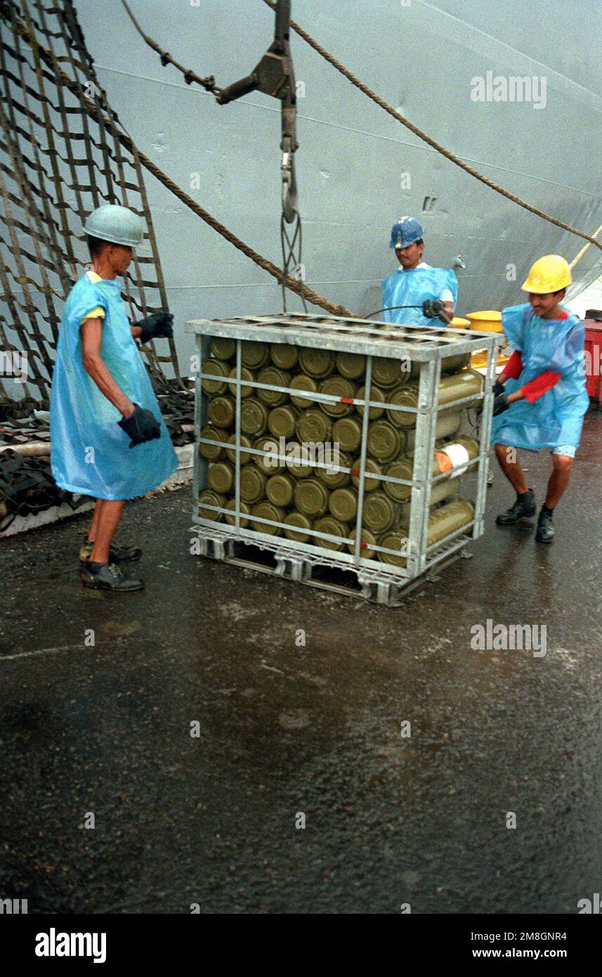 Dock workers prepare to load crates of ordnance on the cargo ship BUYER ...
