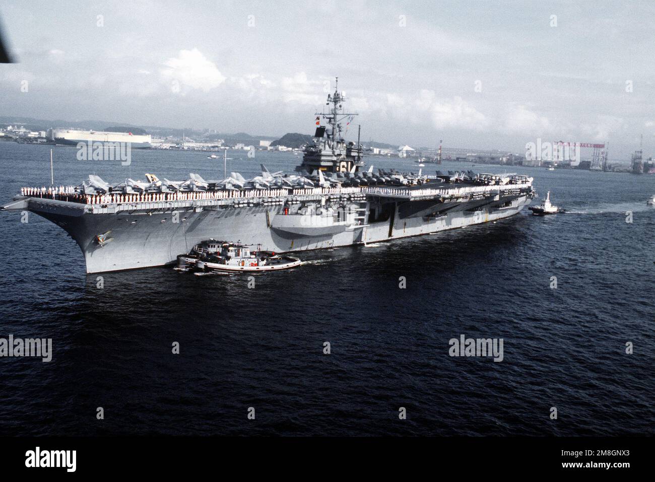 Sailors man the rails aboard the aircraft carrier USS RANGER (CV-61) as ...