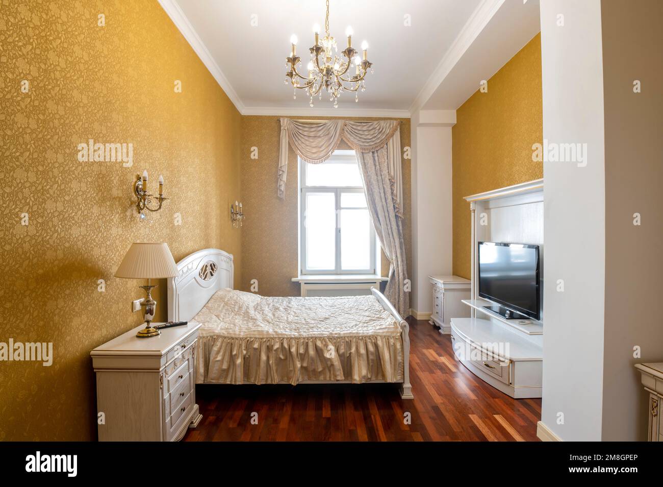 large bright bedroom in yellow tones with huge bed Stock Photo - Alamy
