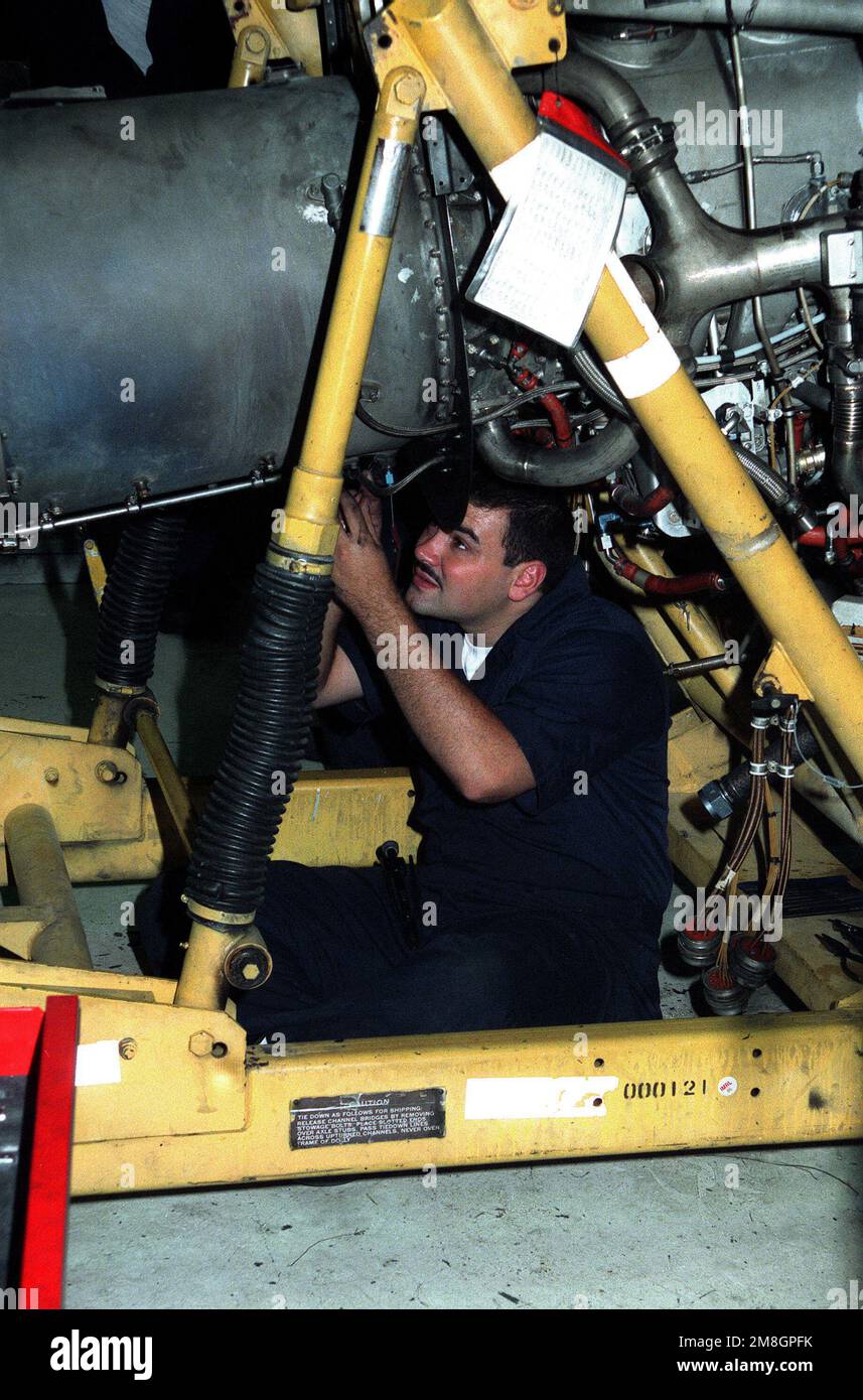 An aviation machinist's mate services an aircraft engine. Base: Naval ...