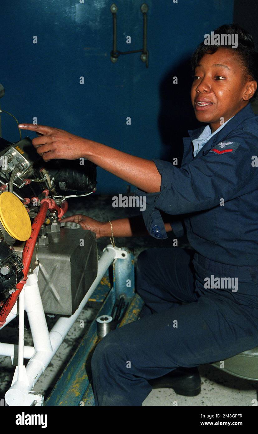 Aviation Machinist's Mate 3rd Class Smith services an aircraft engine ...