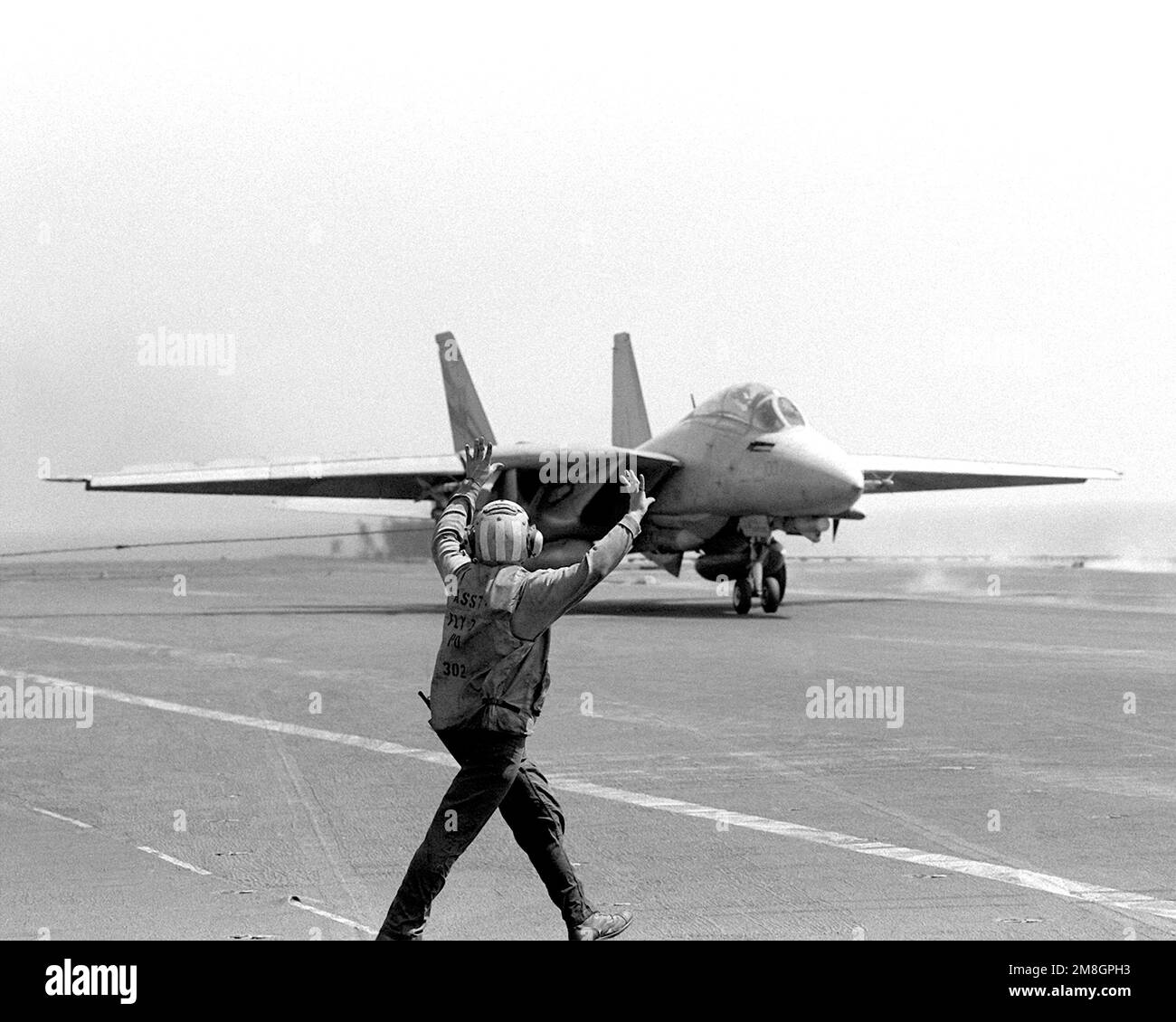 An F-14 Tomcat aircraft stops after landing on the flight deck of the ...