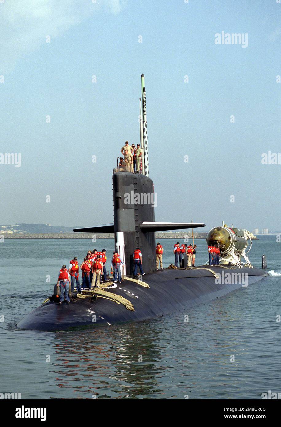 Crewmen stand ready to send mooring lines ashore on the deck of the ...