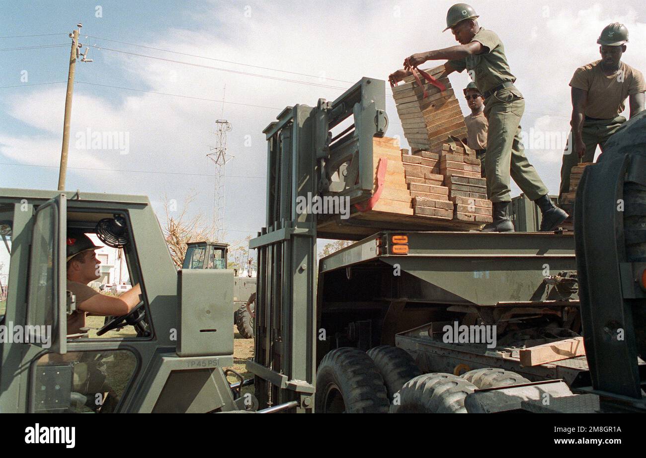Military personnel position construction materials onto a forklift ...