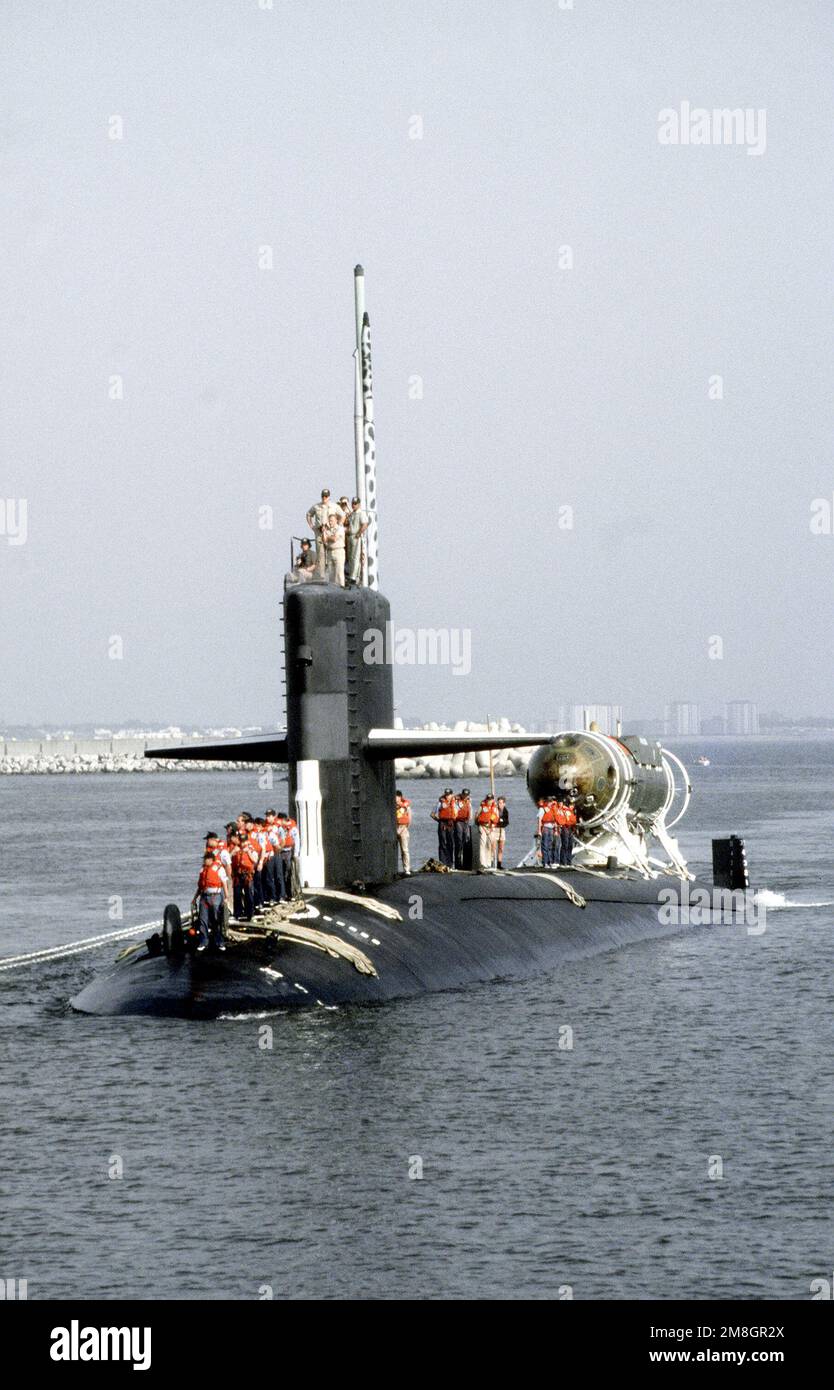 Crewmen stand ready on the deck of the nuclear-powered attack submarine ...