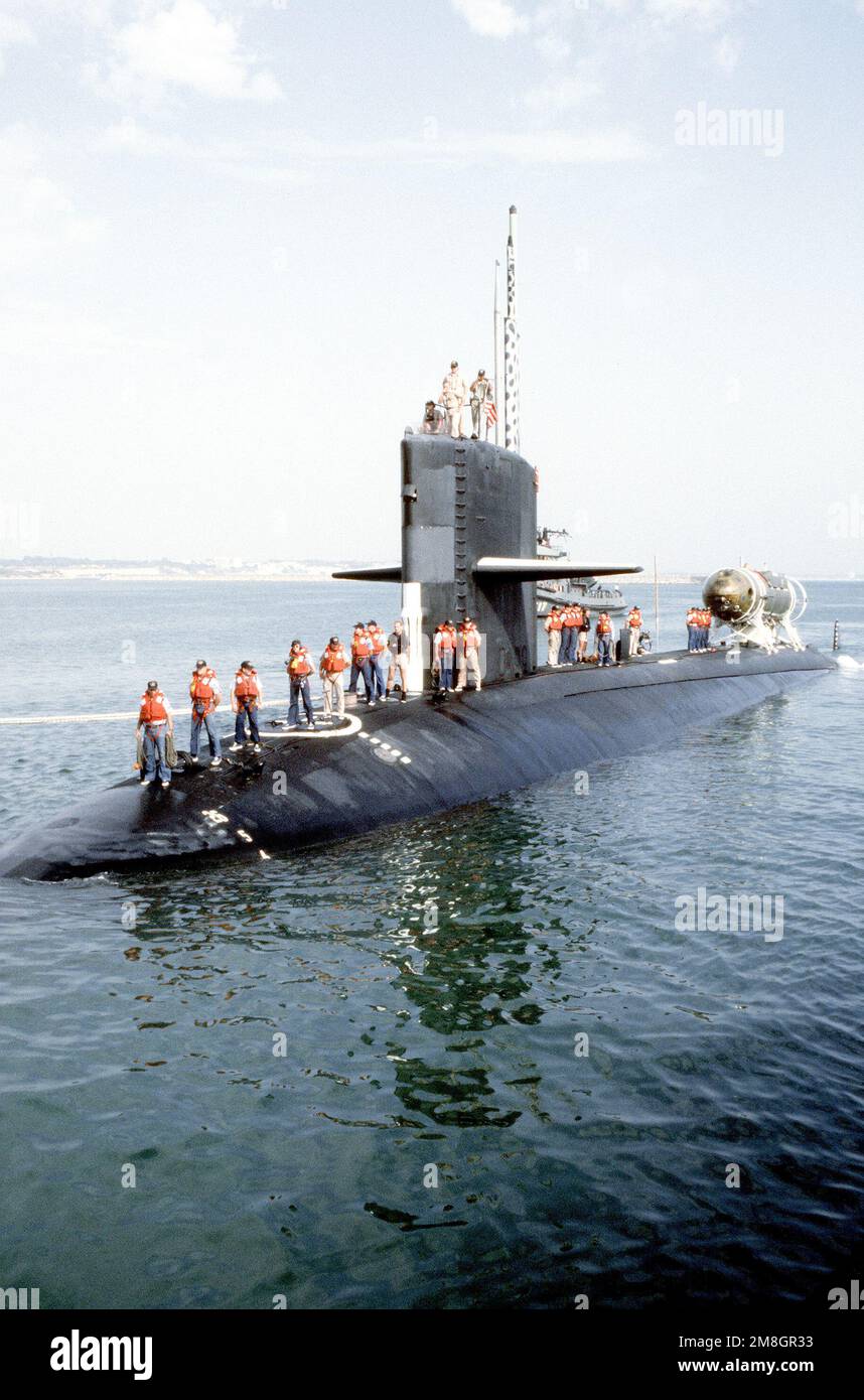 Crewmen stand ready on the deck of the nuclear-powered attack submarine ...