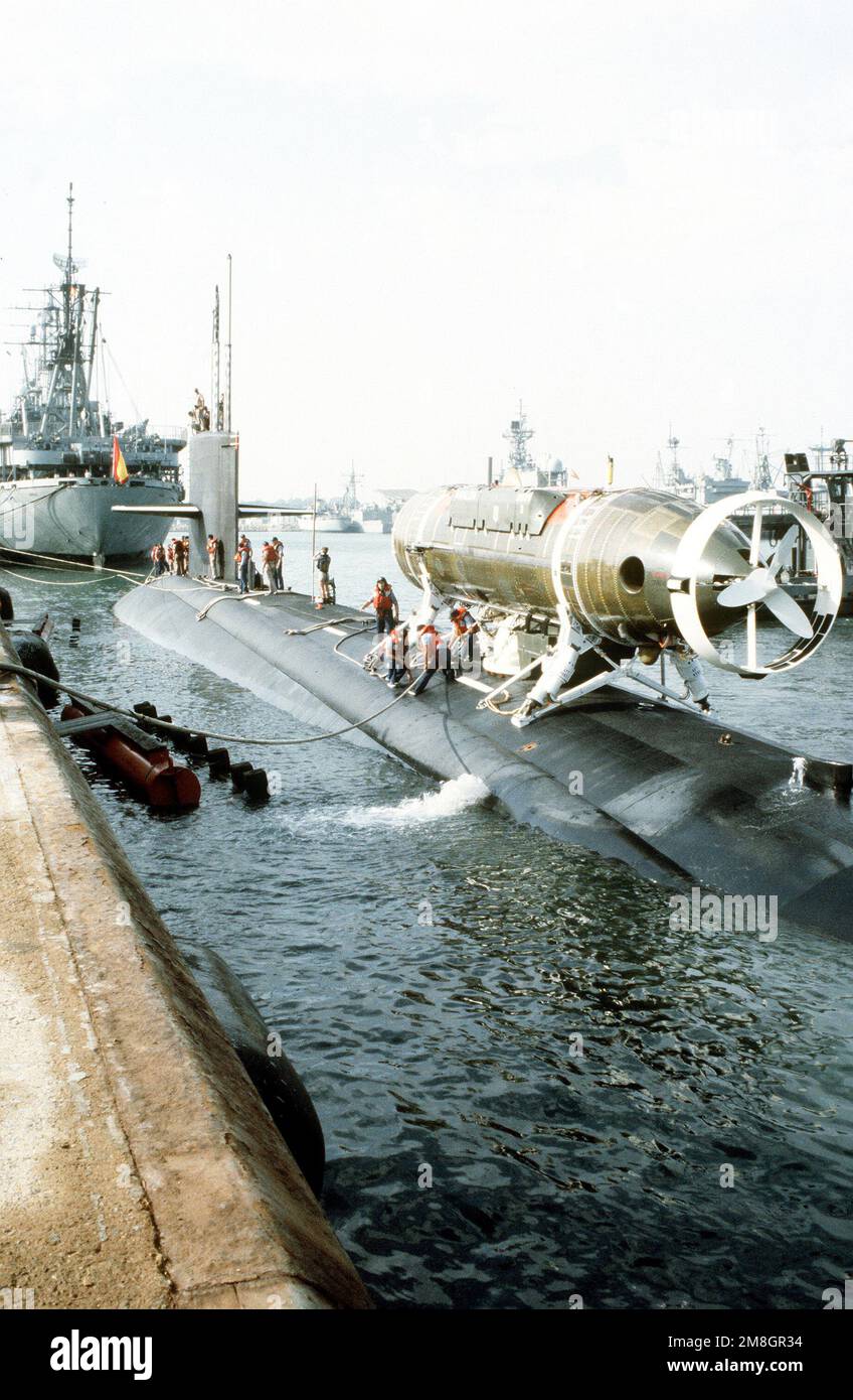 Crewmen work to secure mooring lines on the nuclear-powered attack ...