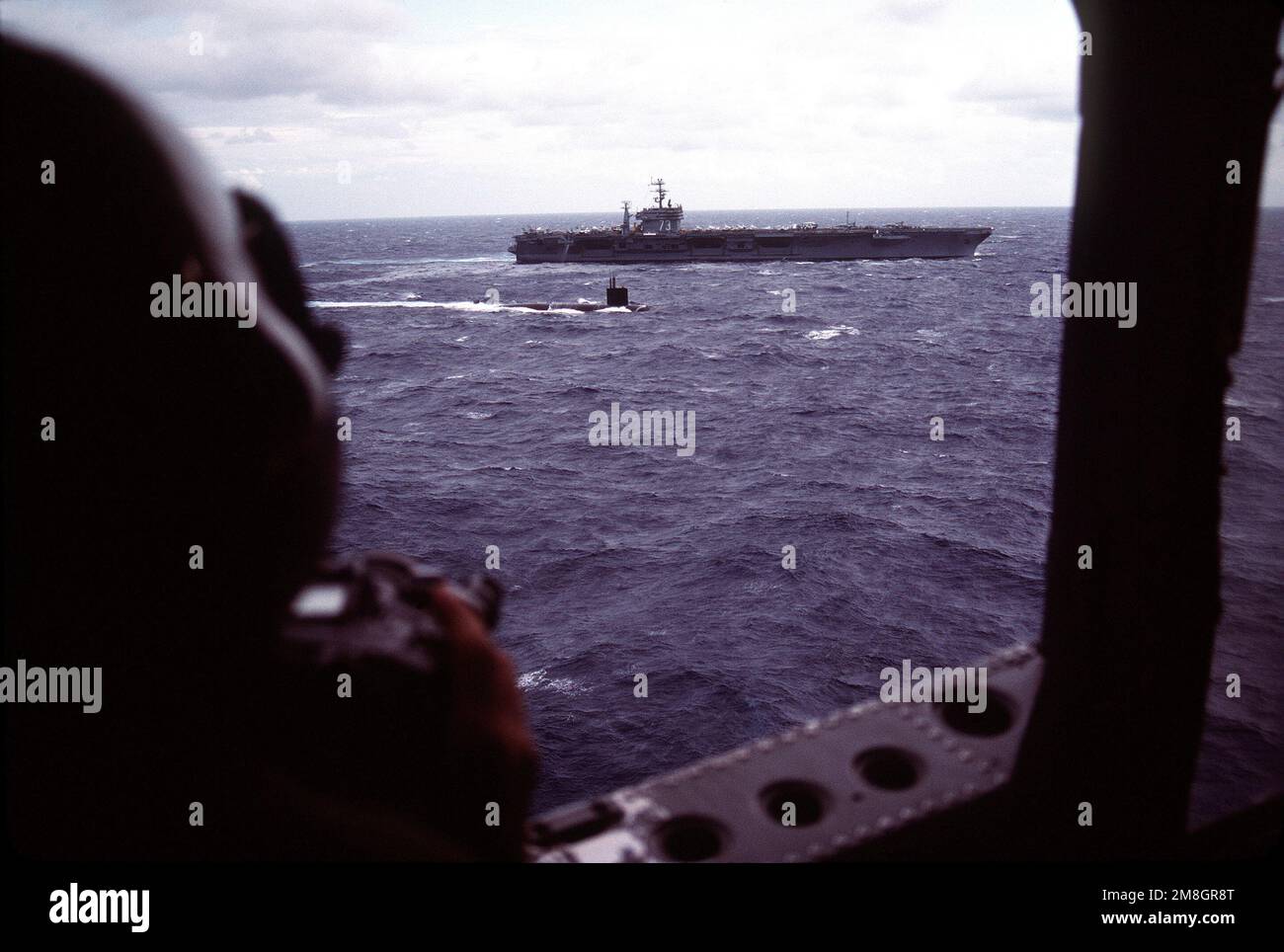 A crew member on an Sh-60 helicopter prepares to photograph the nuclear ...