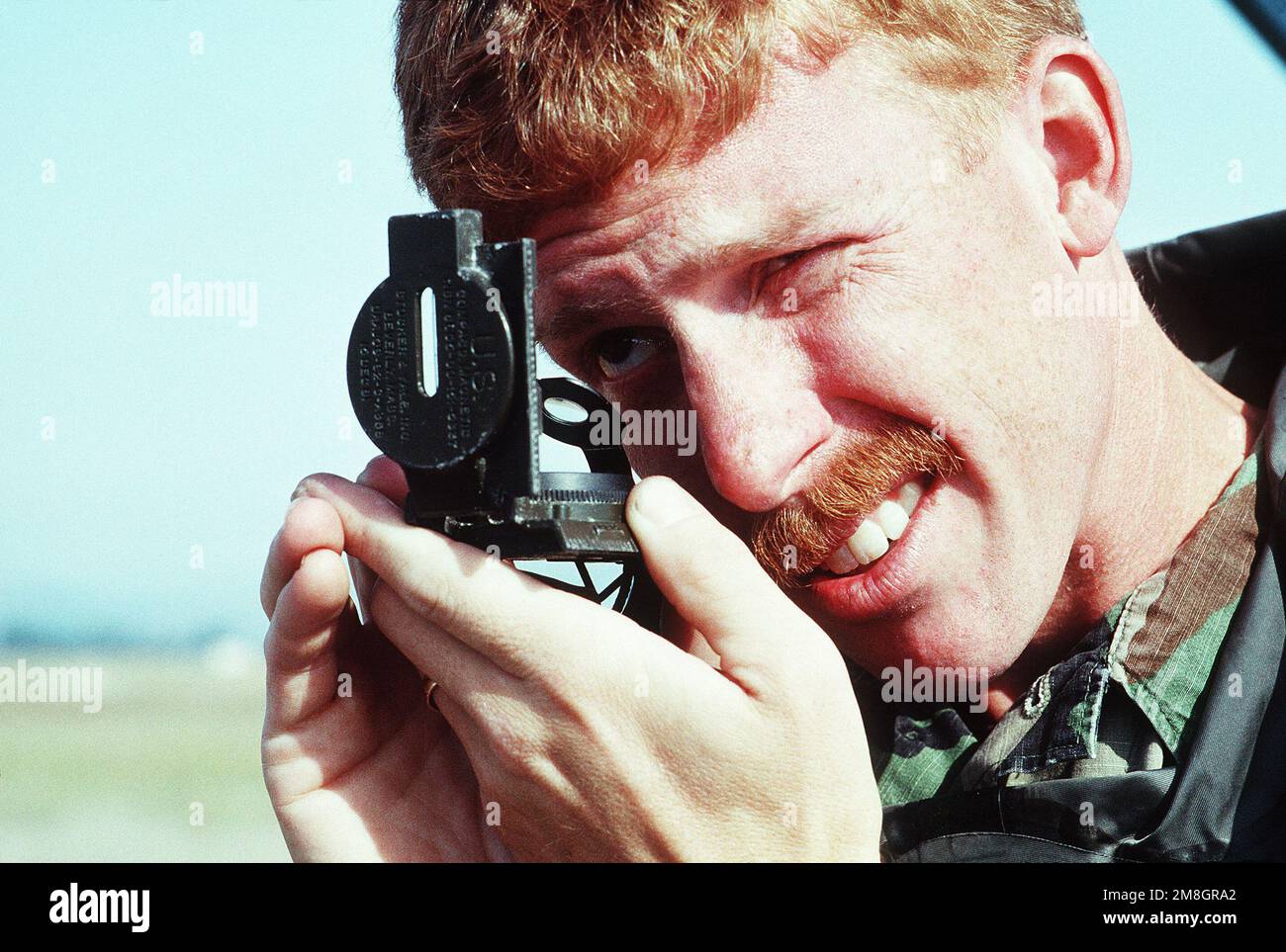 A Navy EOD (explosive ordnance disposal)member takes compass sightings ...