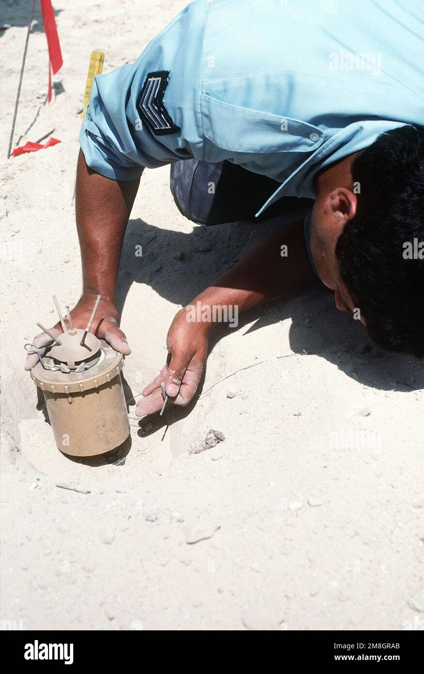 A Kuwaiti sailor checks for anti-handling devices underneath a practice ...