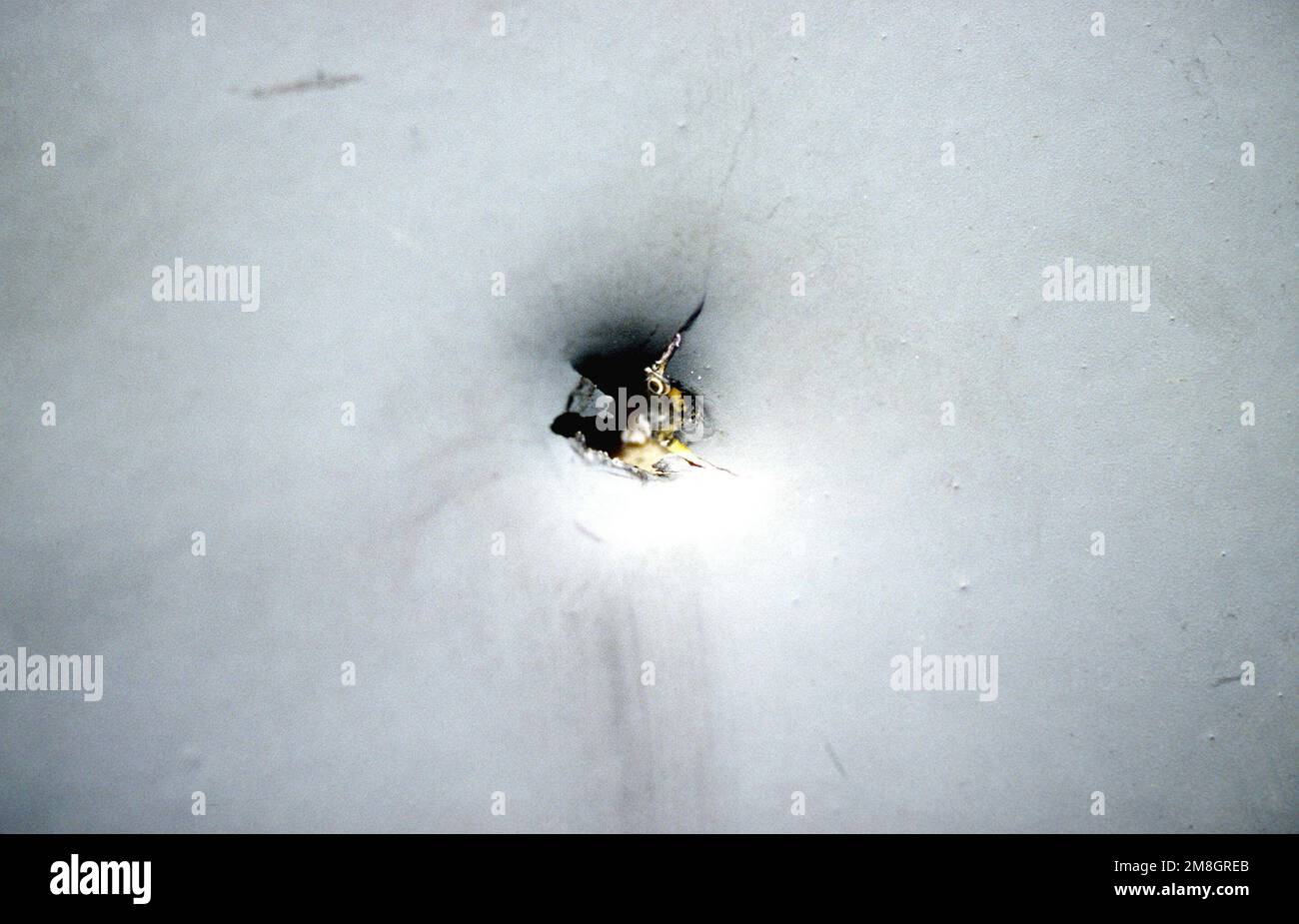 Pictured is a close-up view of a bullet hole in the fuselage of a US ...