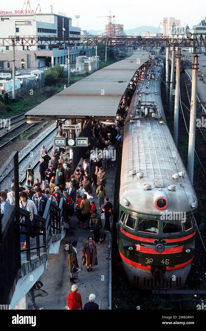 Russian military personnel walk along the platform with other commuters ...