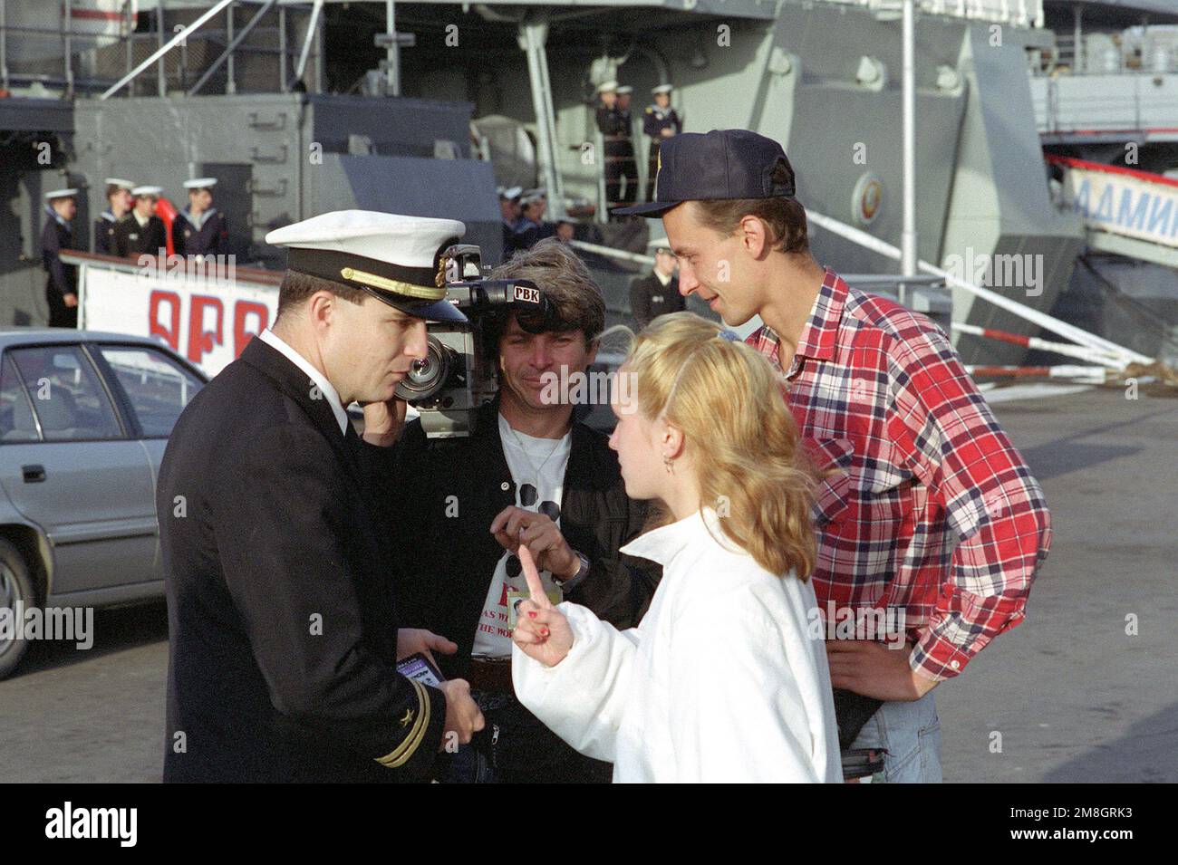 A television cameraman films the meeting as Russian citizens converse ...