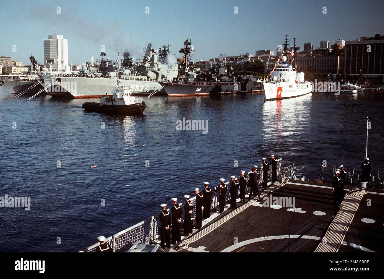 Crew members watch from the stern of the guided missile frigate USS ...