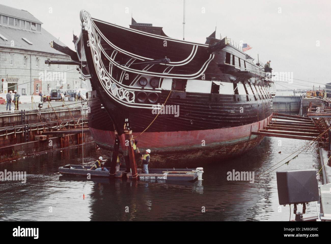 Workers position supports under the bow of the 44-gun sail frigate USS ...