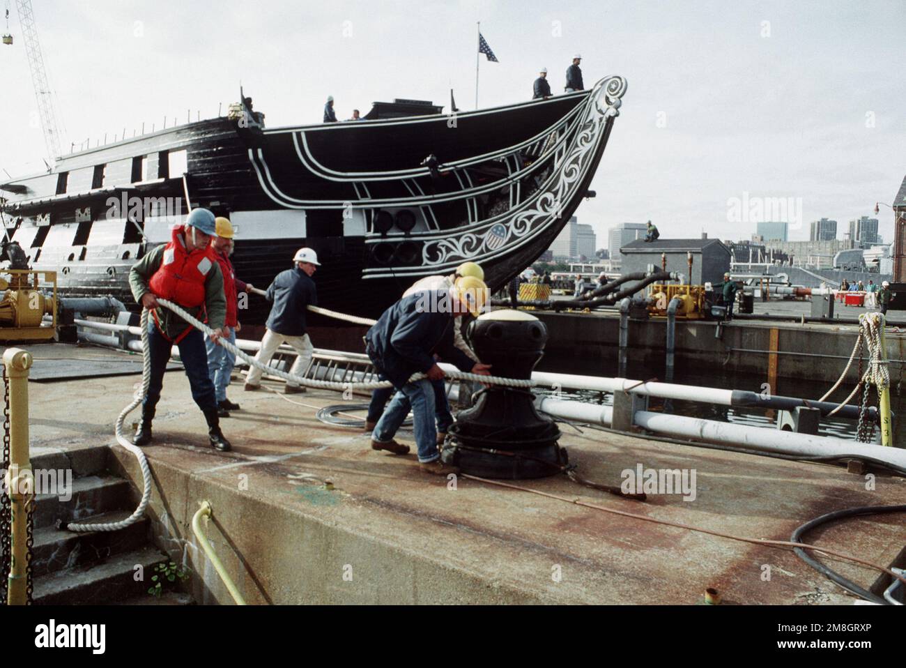 Workers pull the 44-gun sail frigate USS CONSTITUTION in dry dock at ...