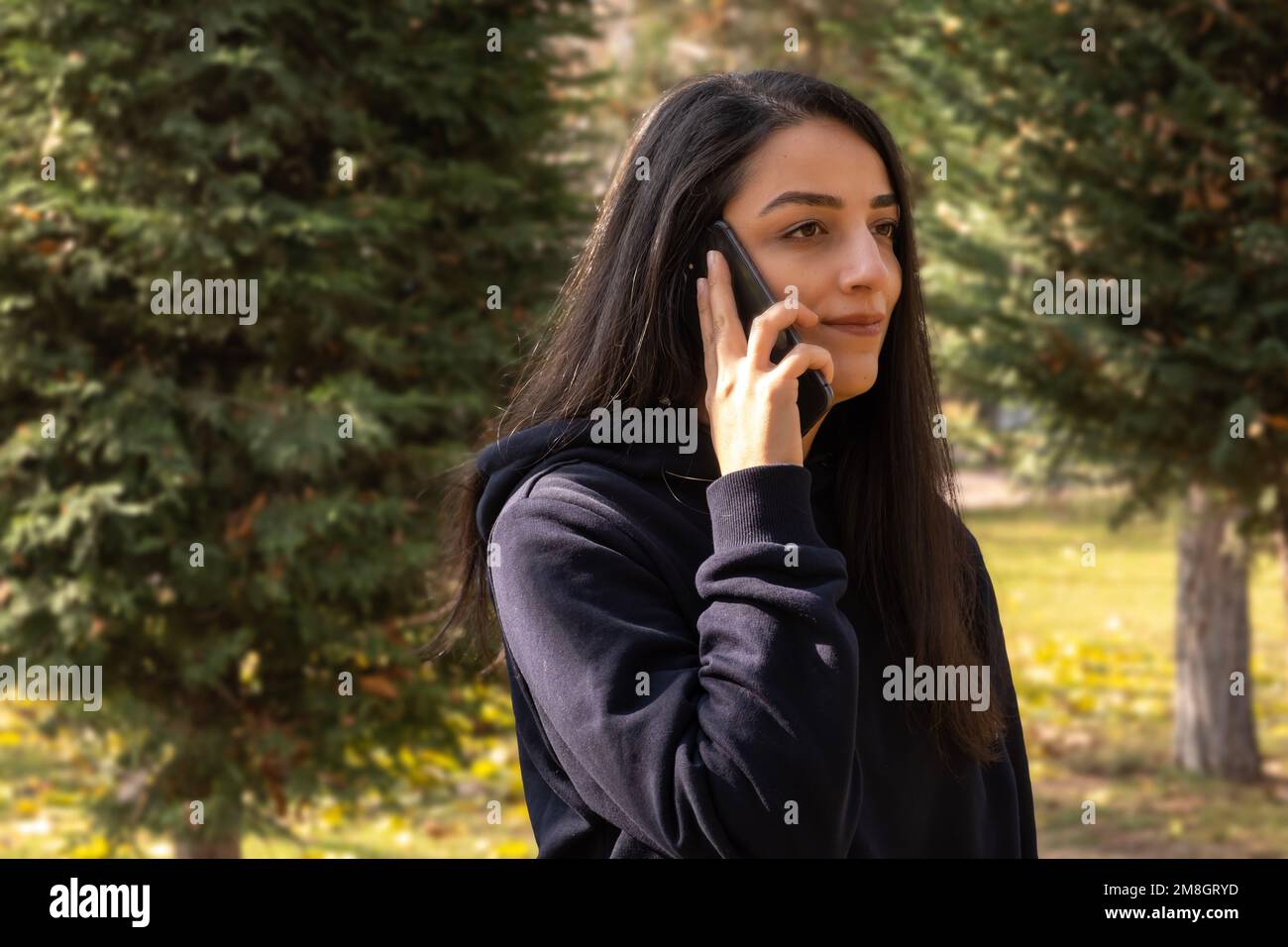 Woman talking to phone. Side view portrait of millennial lady using ...