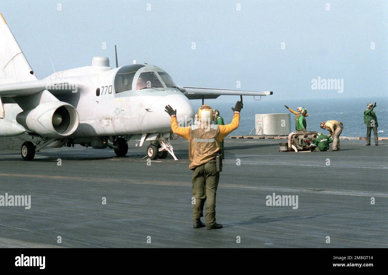A flight deck crewmen signals to the pilot of an Air Test and ...