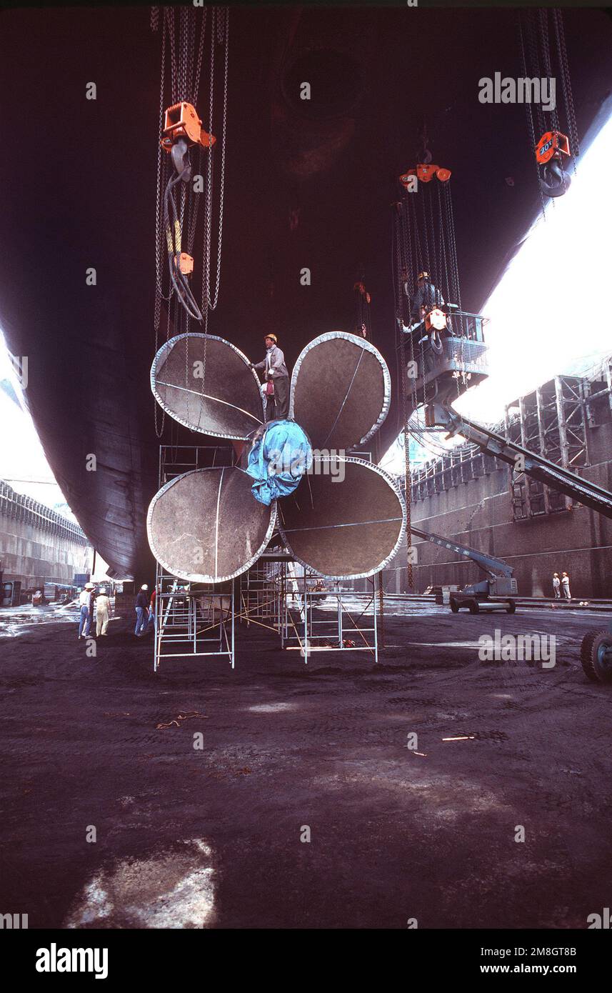 Workers prepare to remove the propeller from the amphibious command ...