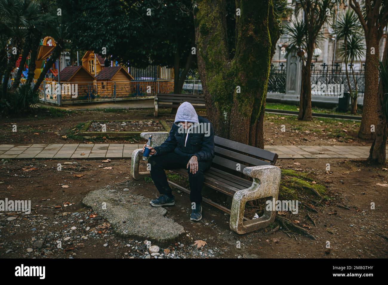 Homeless man or alcoholic sleeping on bench. Poor man on city street ...