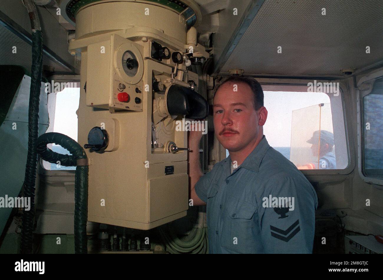 A crew member from the aircraft carrier USS RANGER (CV-61) stands by ...