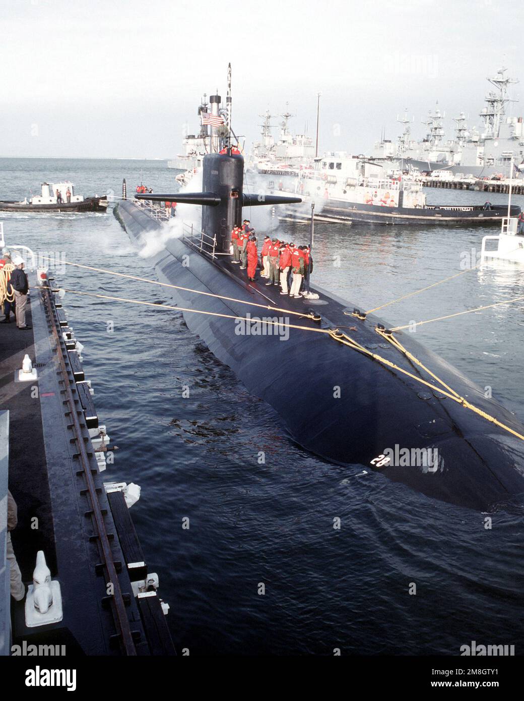 Crewmen watch from the deck as the nuclear-powered attack submarine USS ...