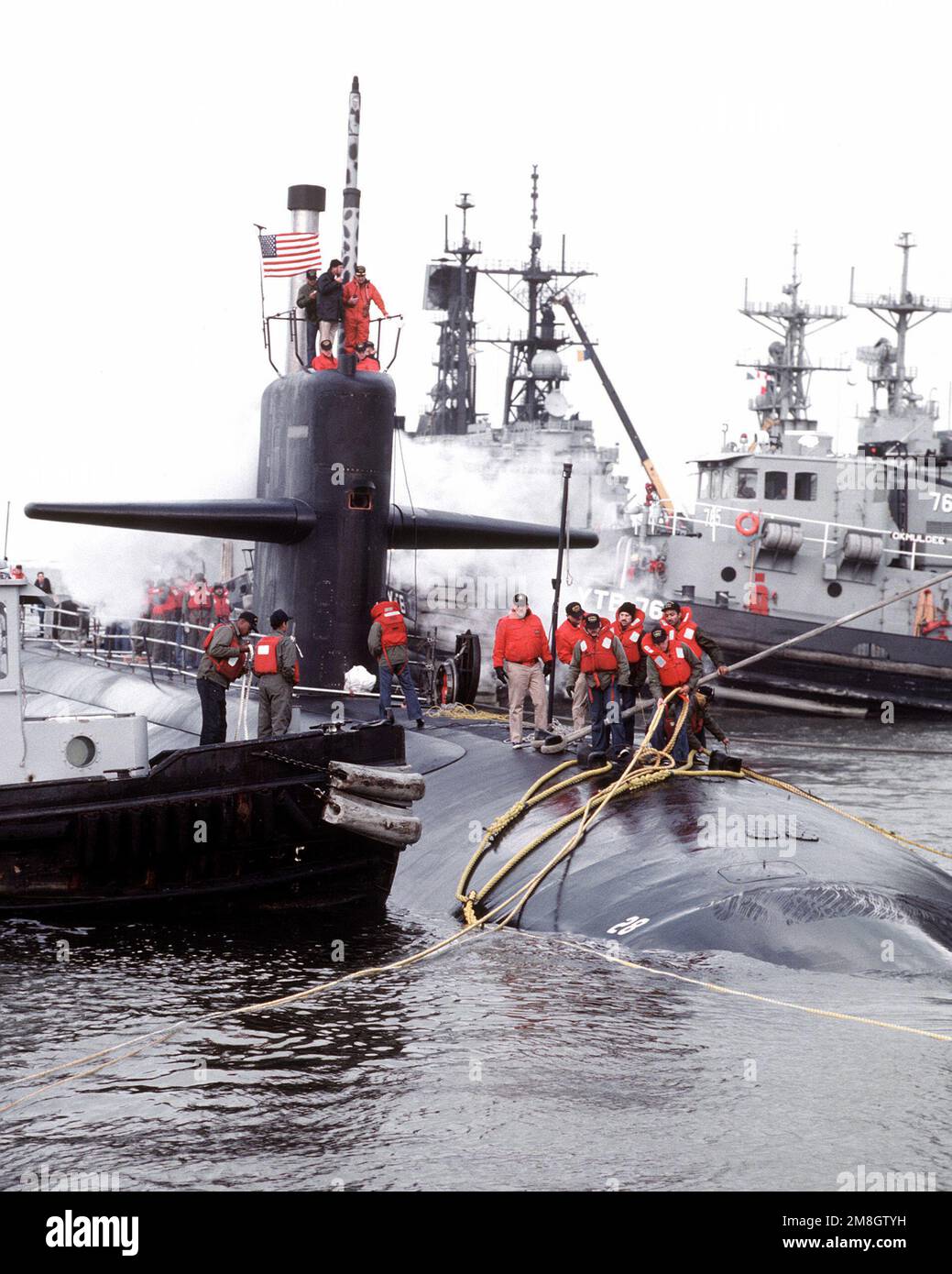 Crewmen secure mooring lines on the bow of the nuclear-powered attack ...