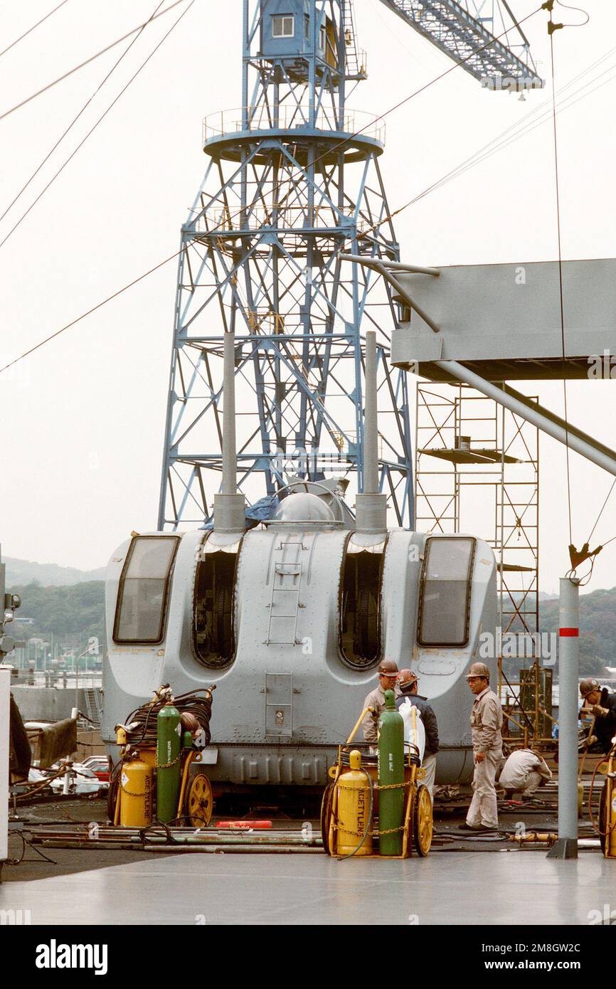 Crew members and civilian workers prepare to remove a Mark 33 3-inch/50 ...
