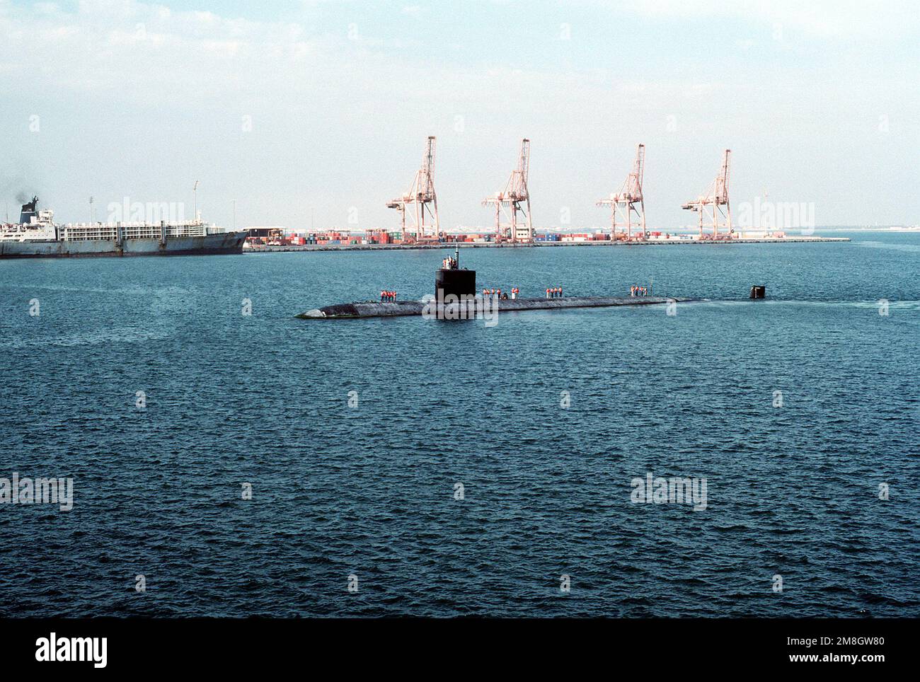 Crew members stand on the deck of the nuclear-powered attack submarine ...