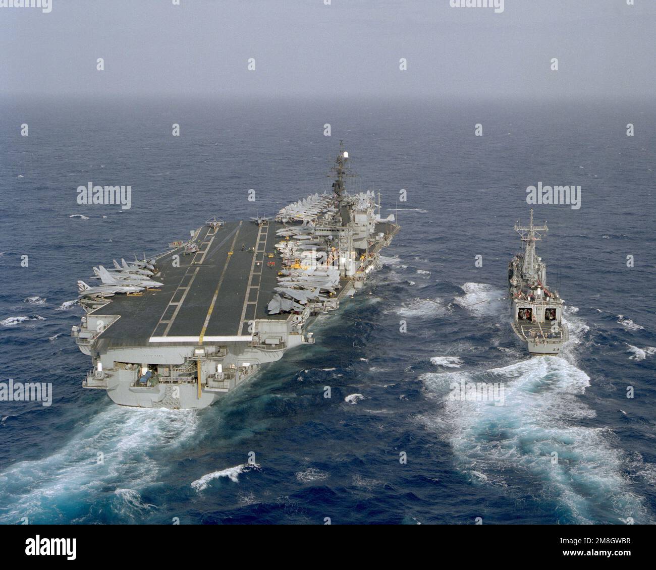 A stern view of the aircraft carrier USS KITTY HAWK (CV-63) taking part ...