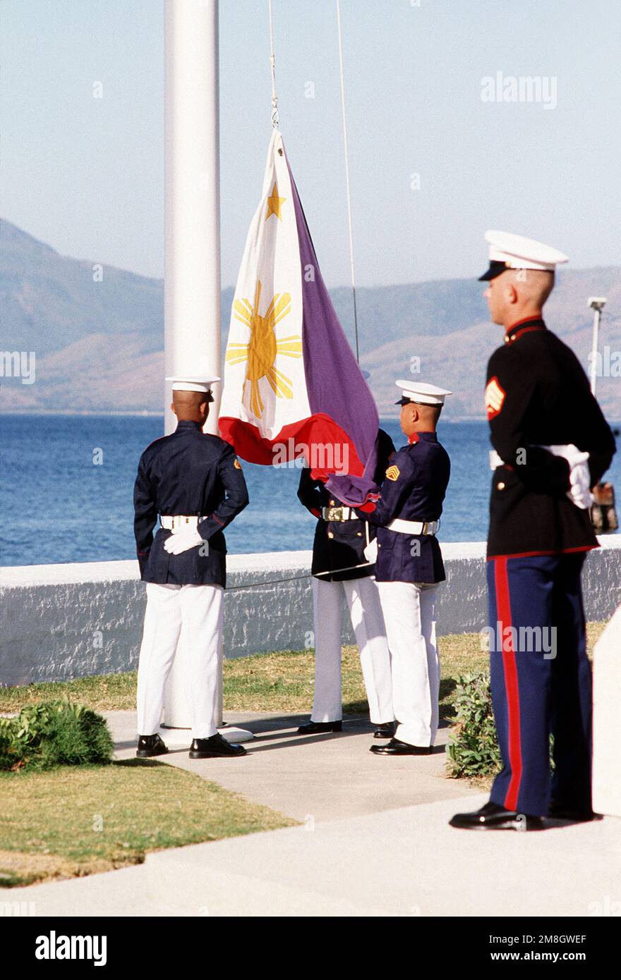 A U.S. Marine stands by as Philippine marines raise their flag over the ...
