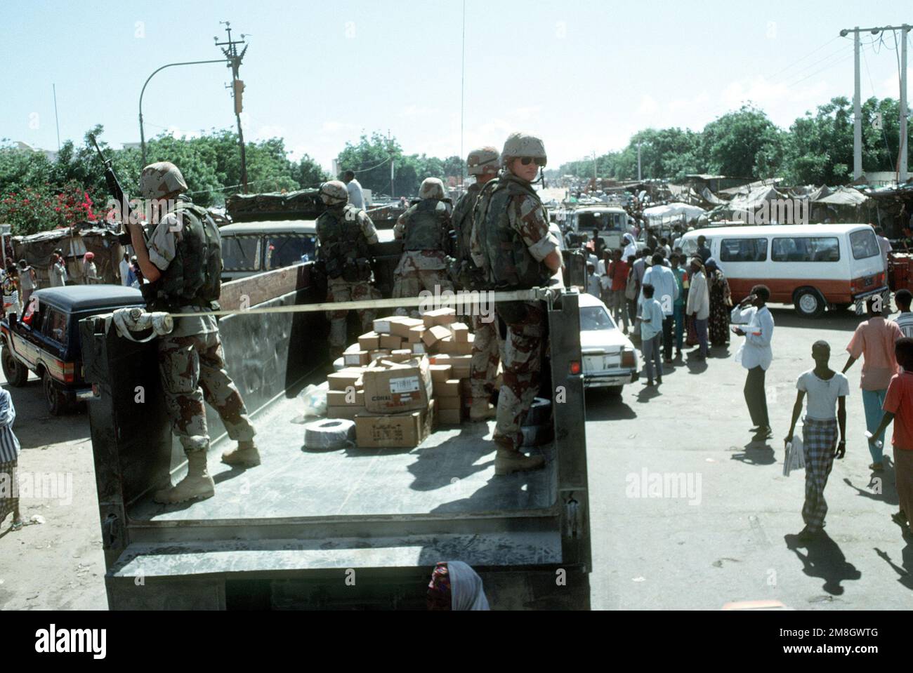 Marines patrol a city street in a dump truck during the multinational ...