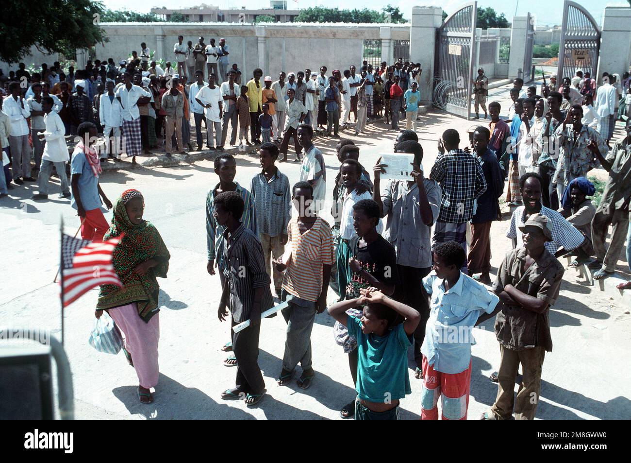 Somalis line the street in front of the gate of the Joint Task Force ...