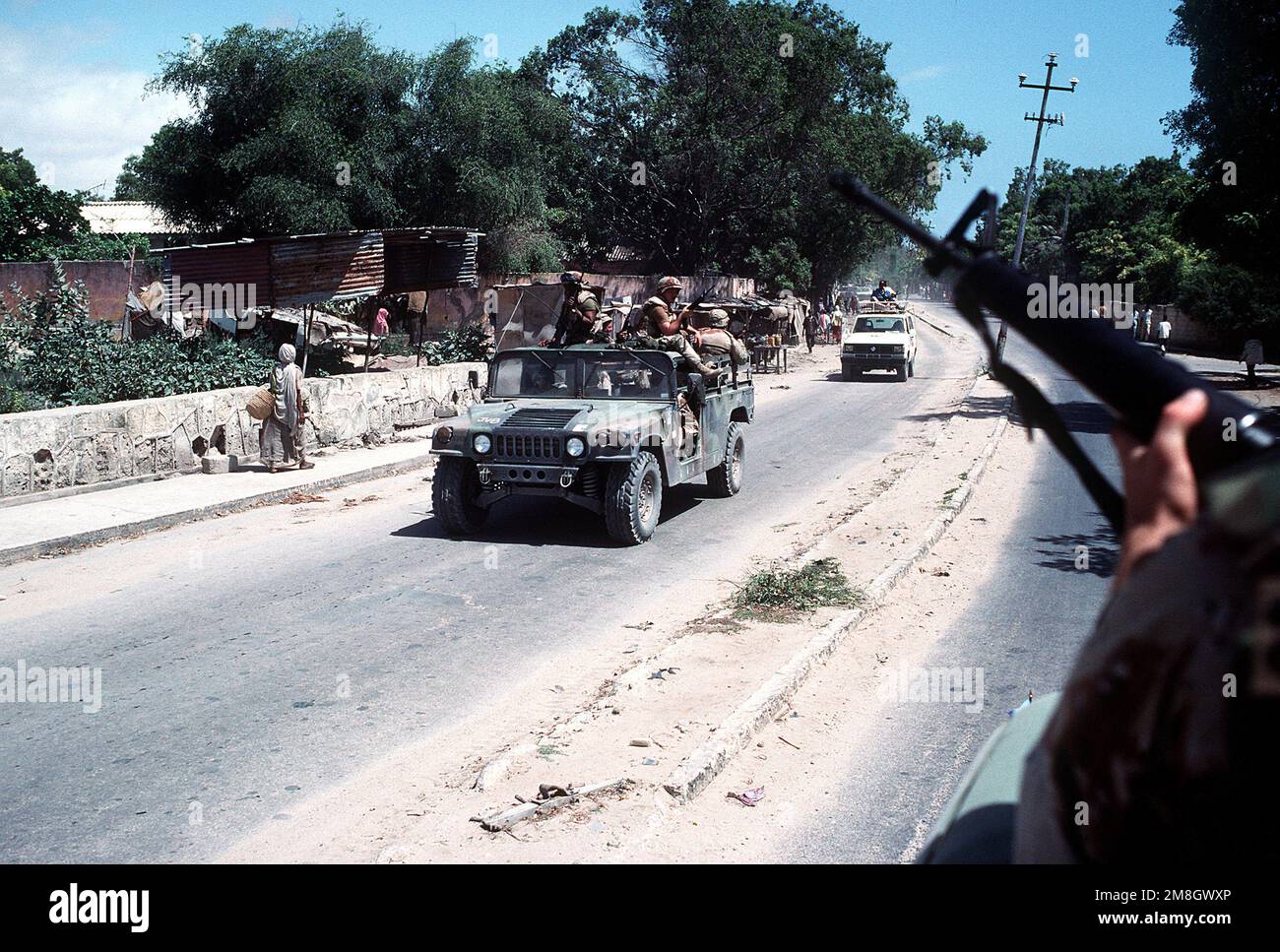 A group of Marines, riding in an M-998 series vehicle, patrol a street ...