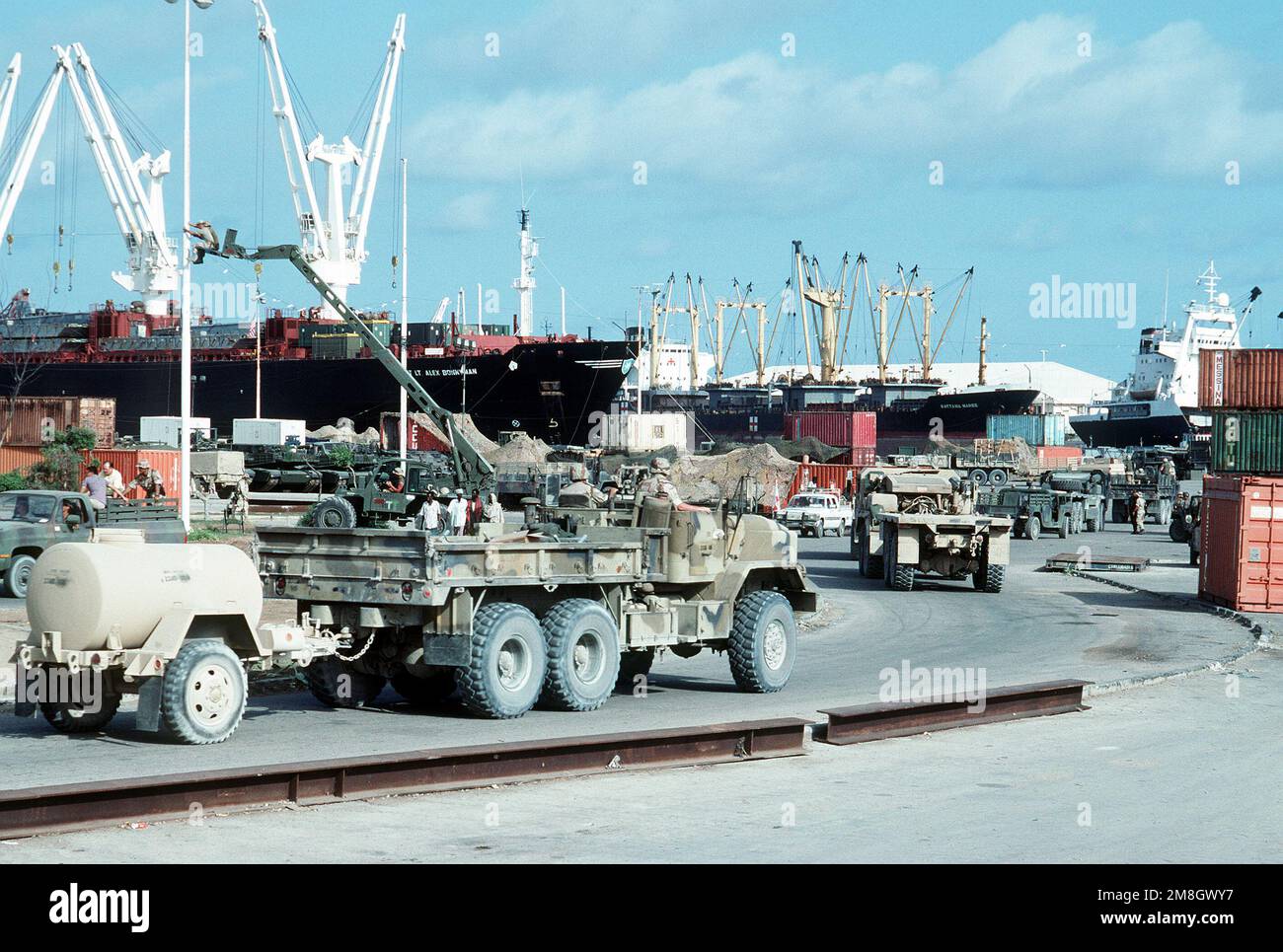 A Marine M-939 series 5-ton truck, towing a water trailer, drives ...