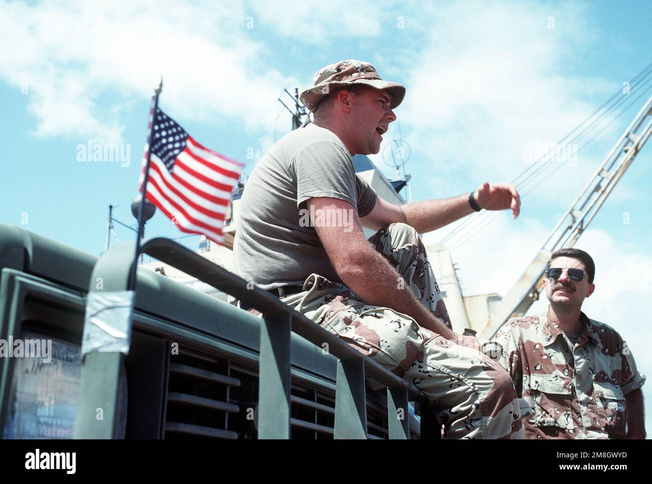 A Seabee addresses a group of men during the multinational relief ...