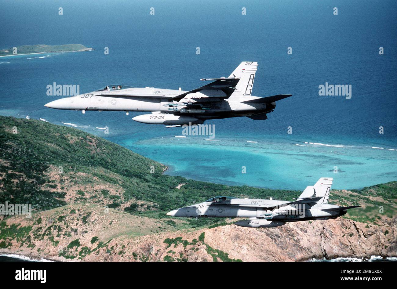 An air-to-air left side view of two Strike Fighter Squadron 136 (VFA ...