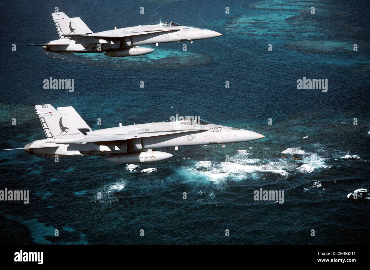 An air-to-air right side view of two Strike Fighter Squadron 136 (VFA ...