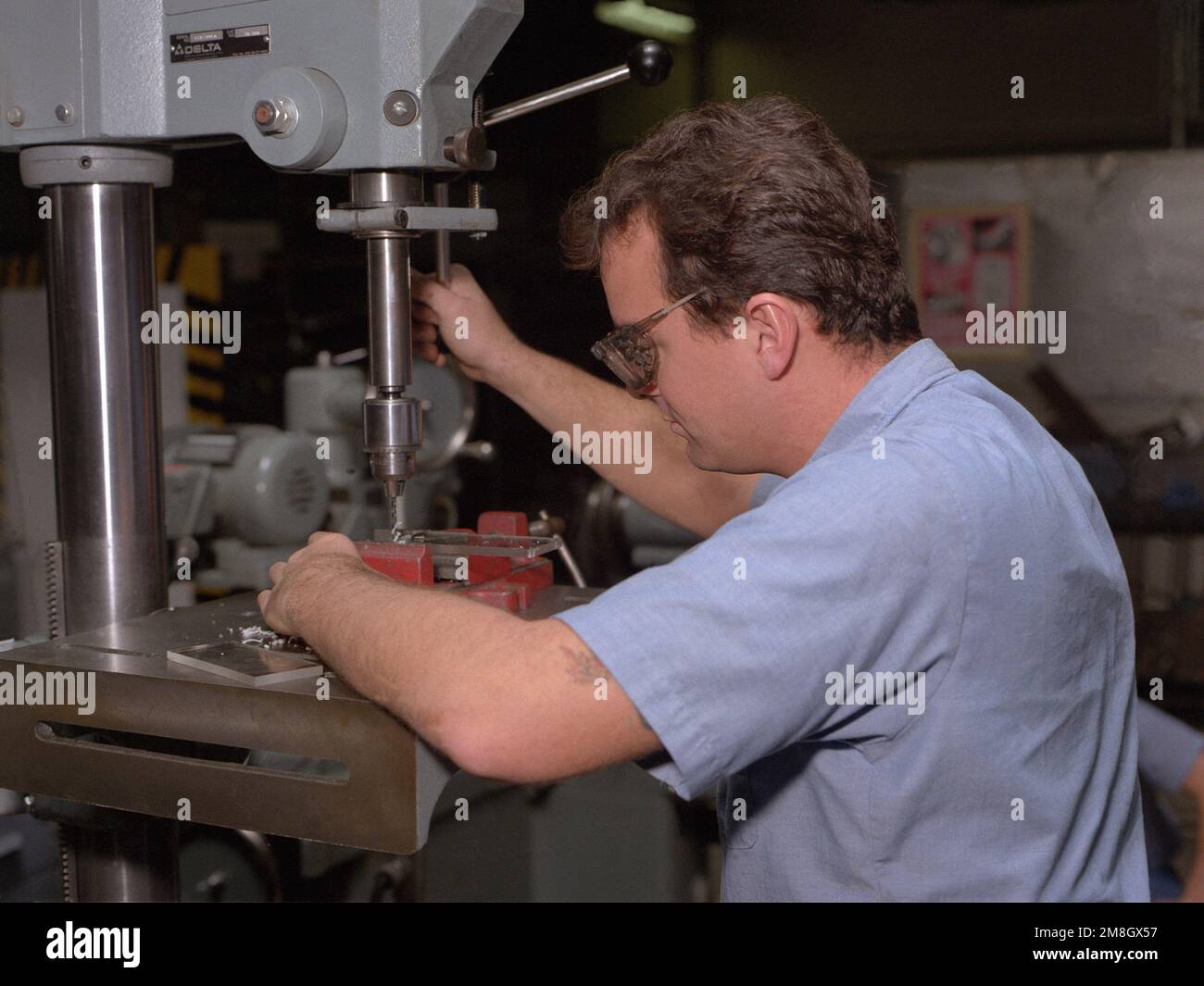 Aviation Structural Mechanic 3rd Class Garrett uses a drill press to ...